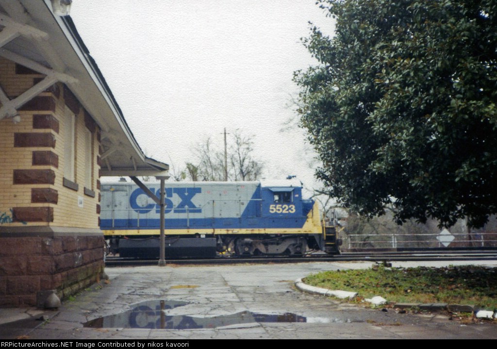 CSX 5523 reflects in a pool of water on a dreary day